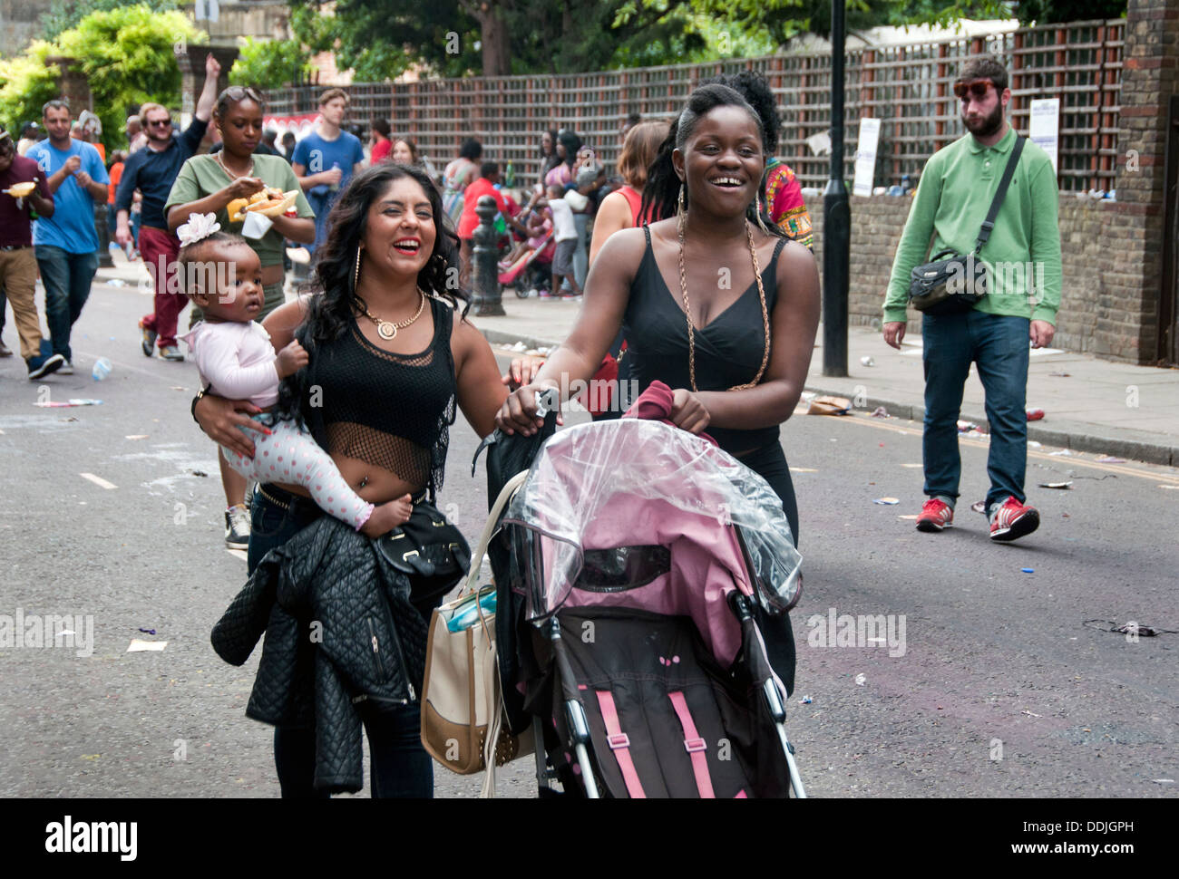 Young mothers chatting in urban street with push chairs and babies ...
