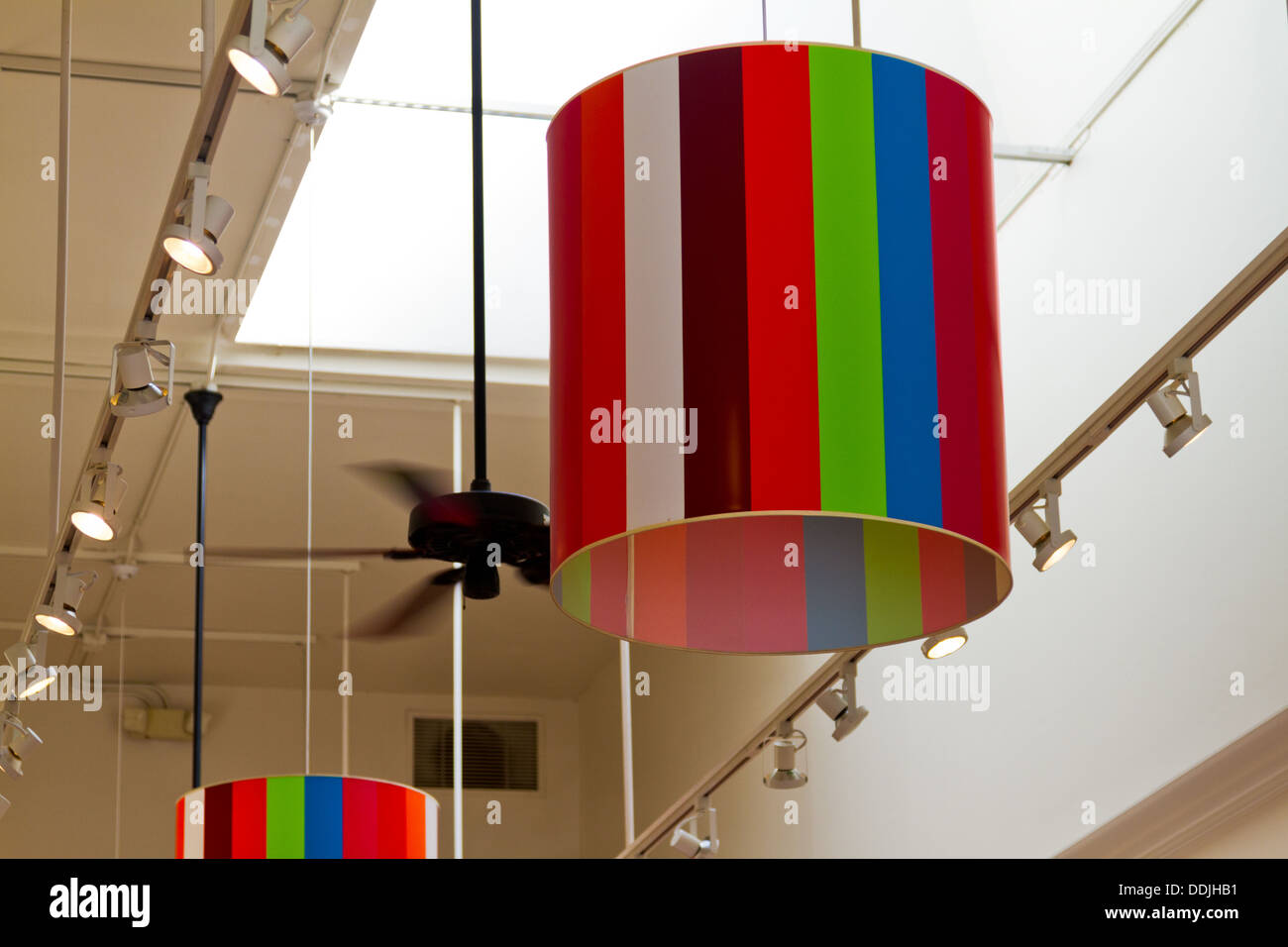 Brightly colored striped lamp shades hanging in a skylit store Stock ...