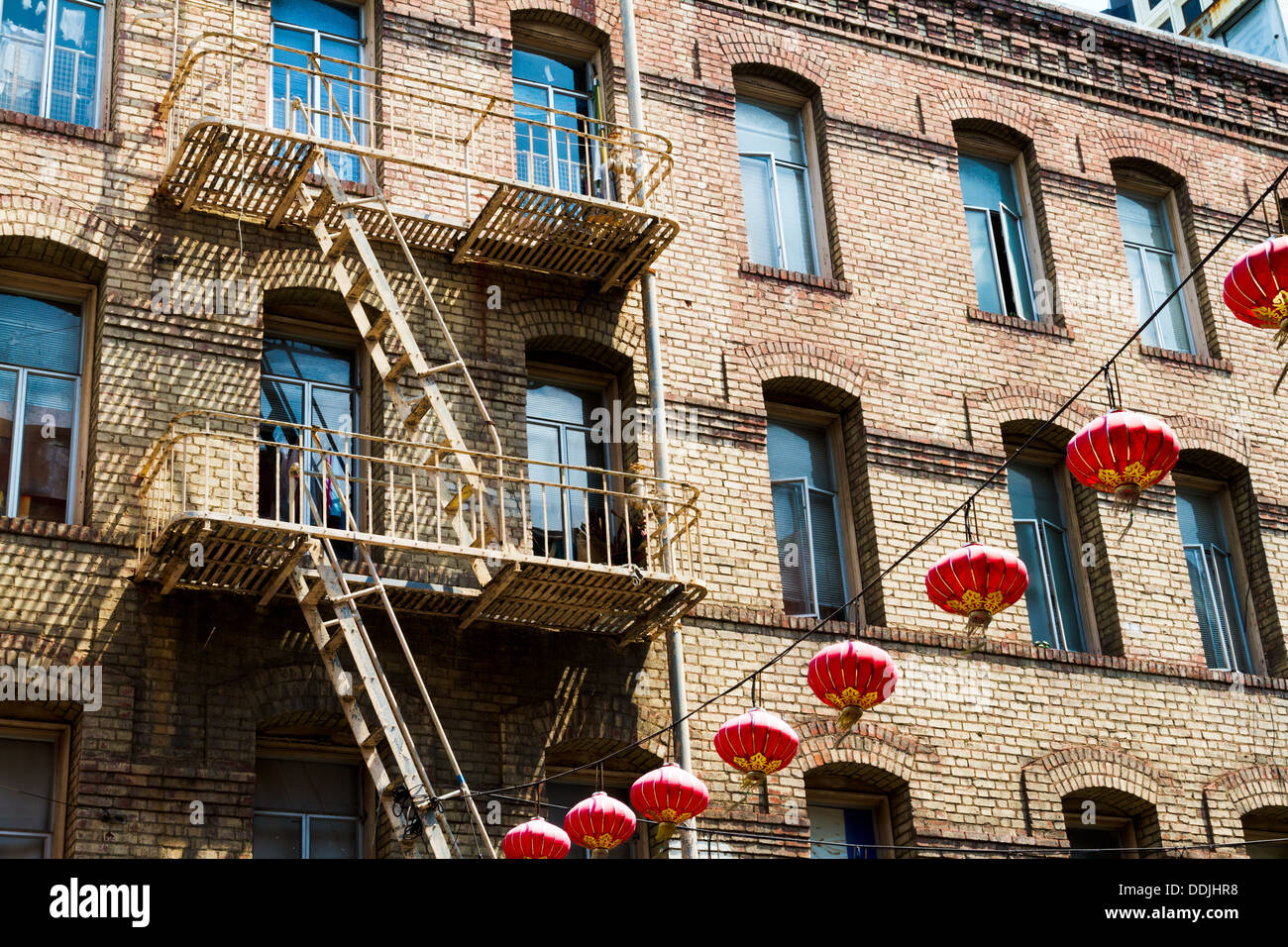 Brick building with fire escape in Chinatown, San Francisco decorated ...