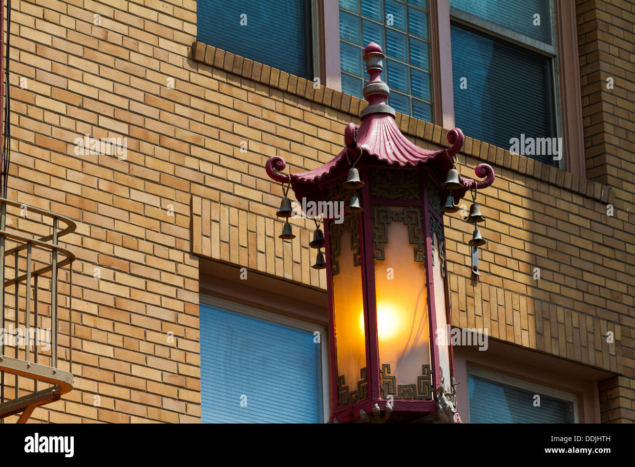 Traditional Chinese street lamp glowing in front of a brick building in ...