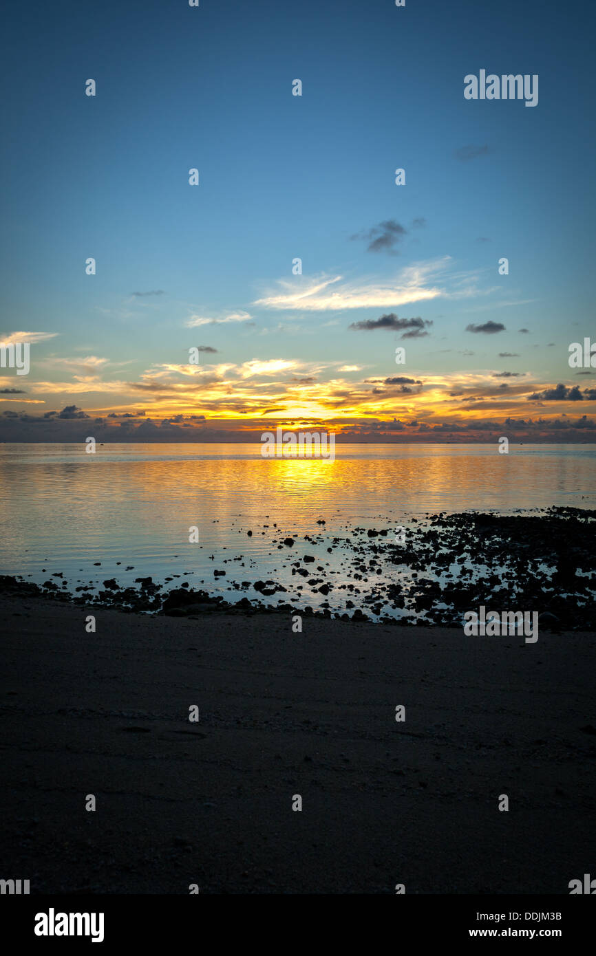 Sunset colors with reflection over the ocean at Amuri Beach in Aitutaki ...