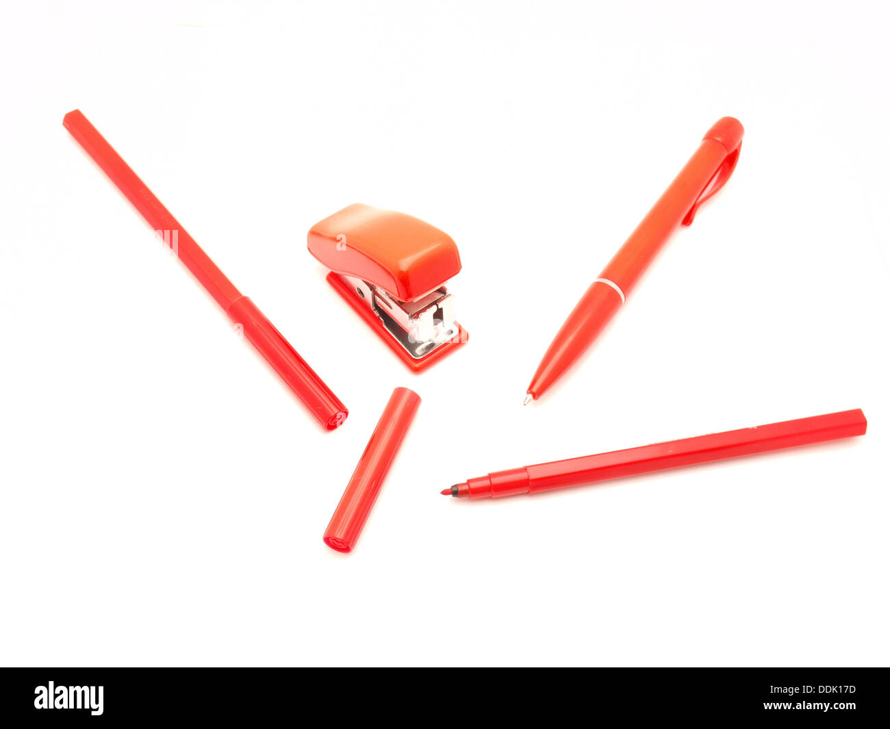 Reds a stapler, the handle and a felt-tip pen on a white background ...