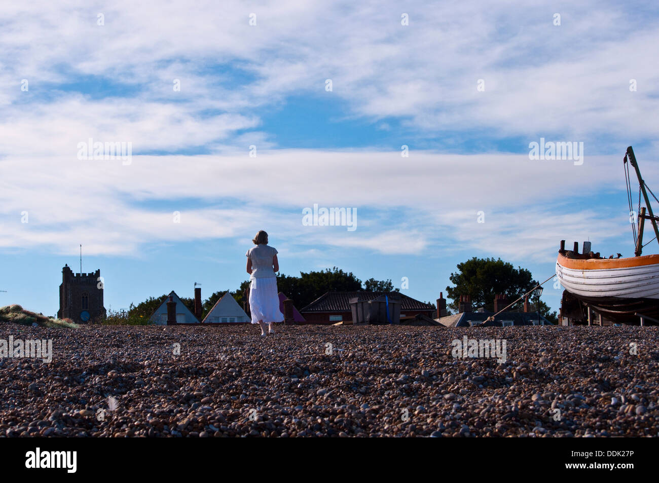 woman walking on shingle beach Stock Photo - Alamy
