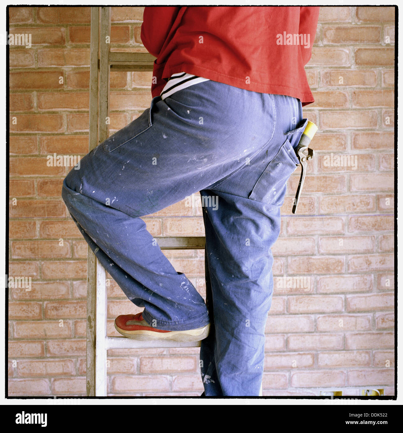 Man climbing up brick wall hi-res stock photography and images - Alamy