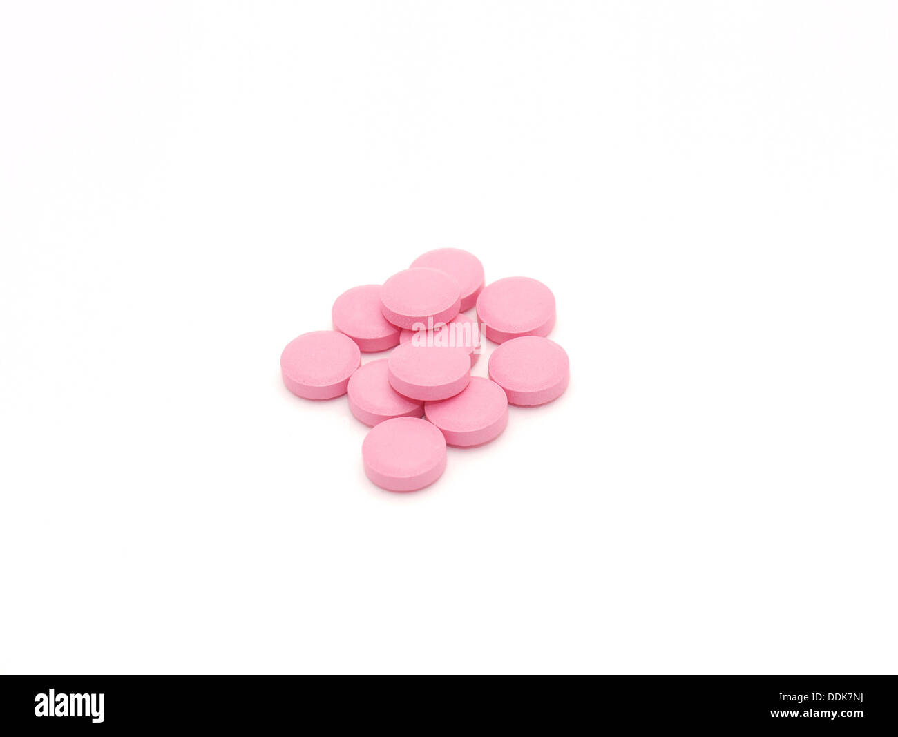 Pink tablets on a white background Stock Photo - Alamy