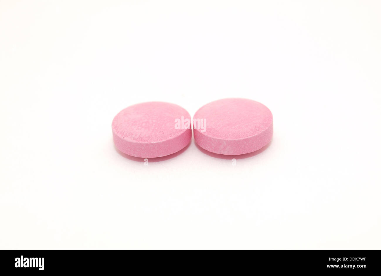 Pink tablets on a white background Stock Photo - Alamy