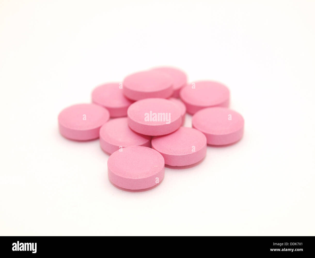 Pink tablets on a white background Stock Photo - Alamy