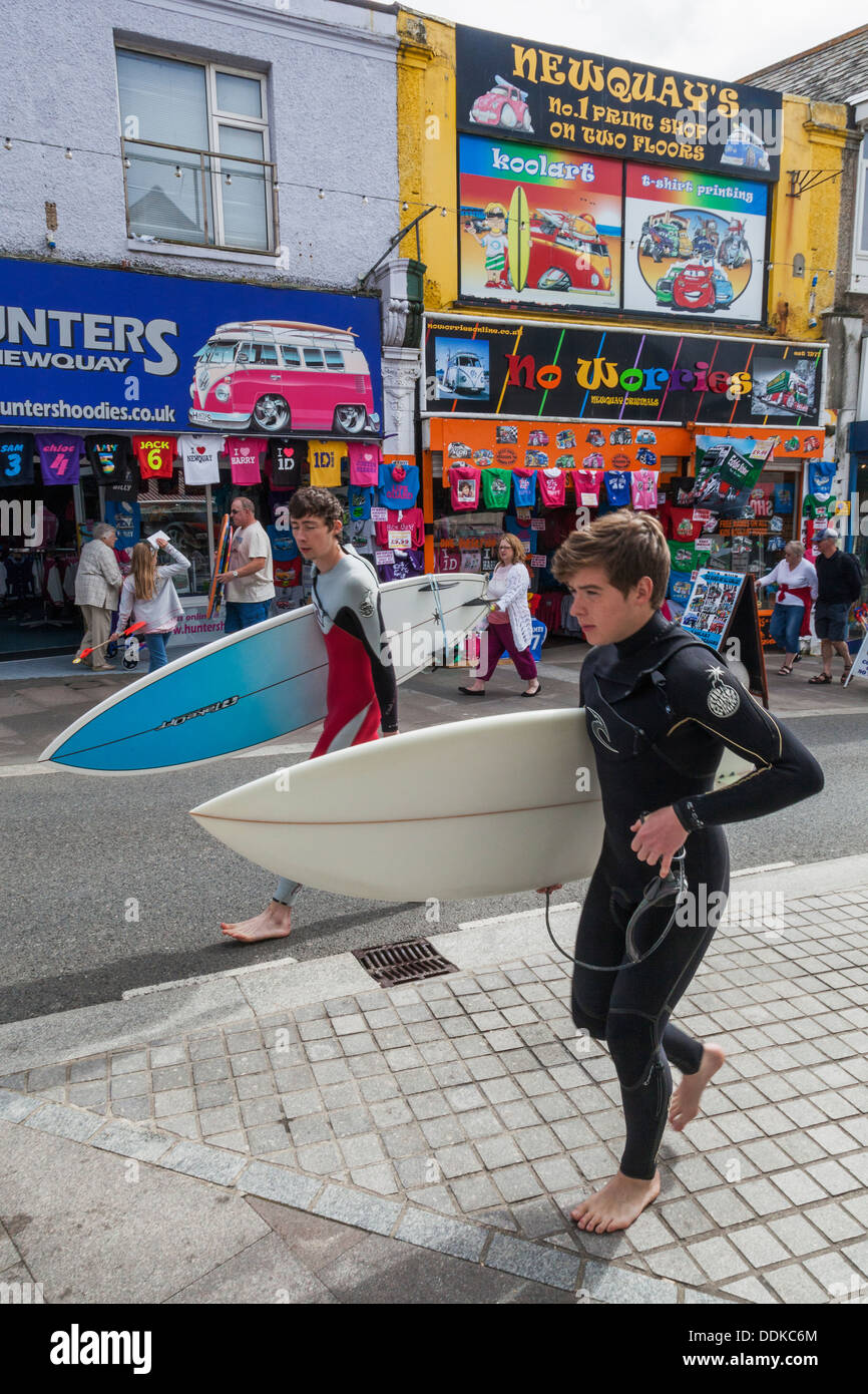 England, Cornwall, Newquay, Surfers Walking Past Colourful Shops in ...