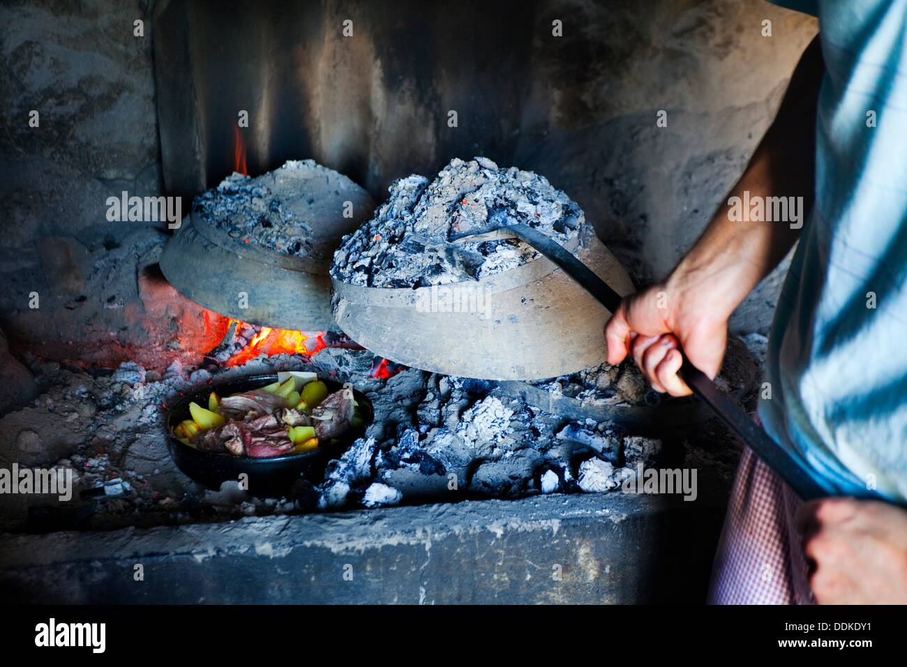 Baking of lamb and potatoes to the live coal in the peka in cast iron ...