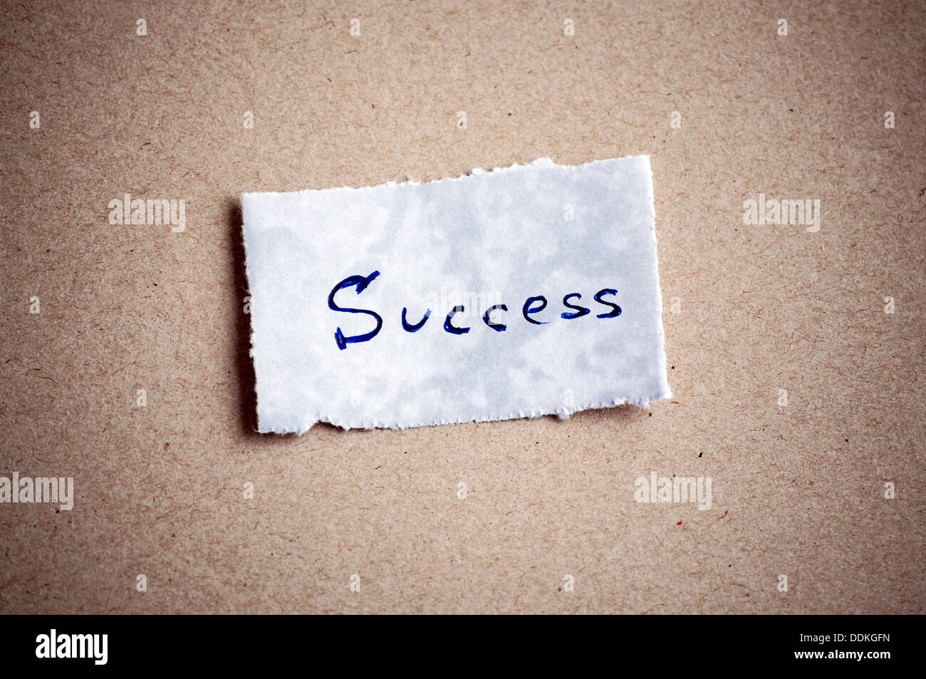 Success message,written on piece of paper, on cardboard background ...