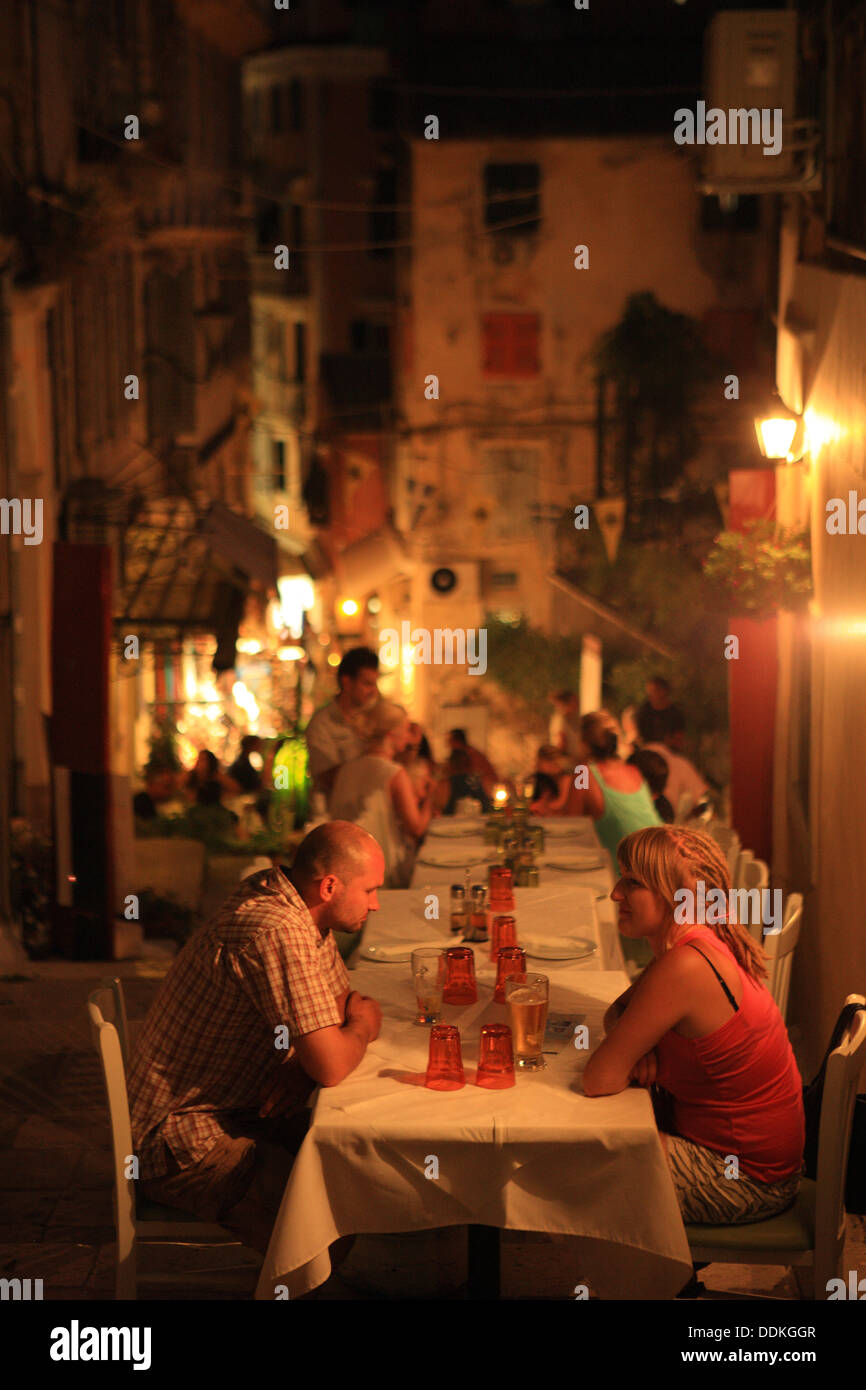 People eating at night outside in the quaint streets of Corfu Town ...
