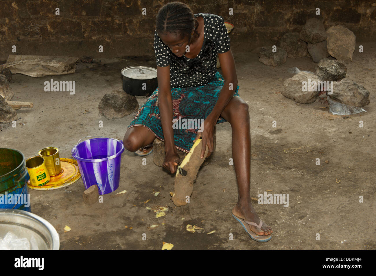 Cook peeling a yam in a kitchen with 3 stone fire, Nigeria Stock Photo ...