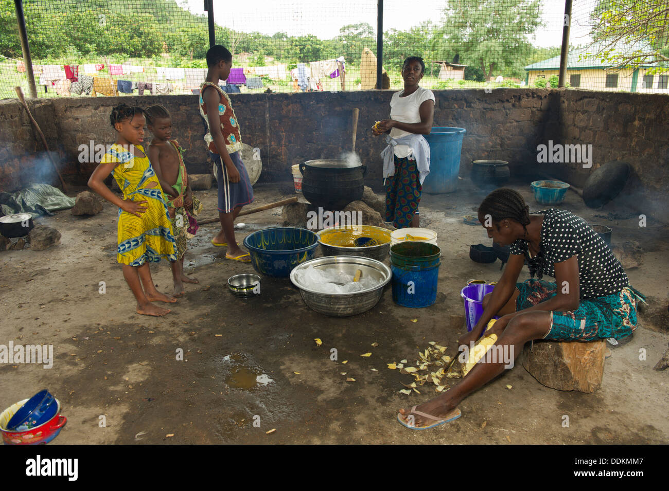 Cook preparing meal in an outdoor kitchen on a 3 stone fire in Otutulu ...