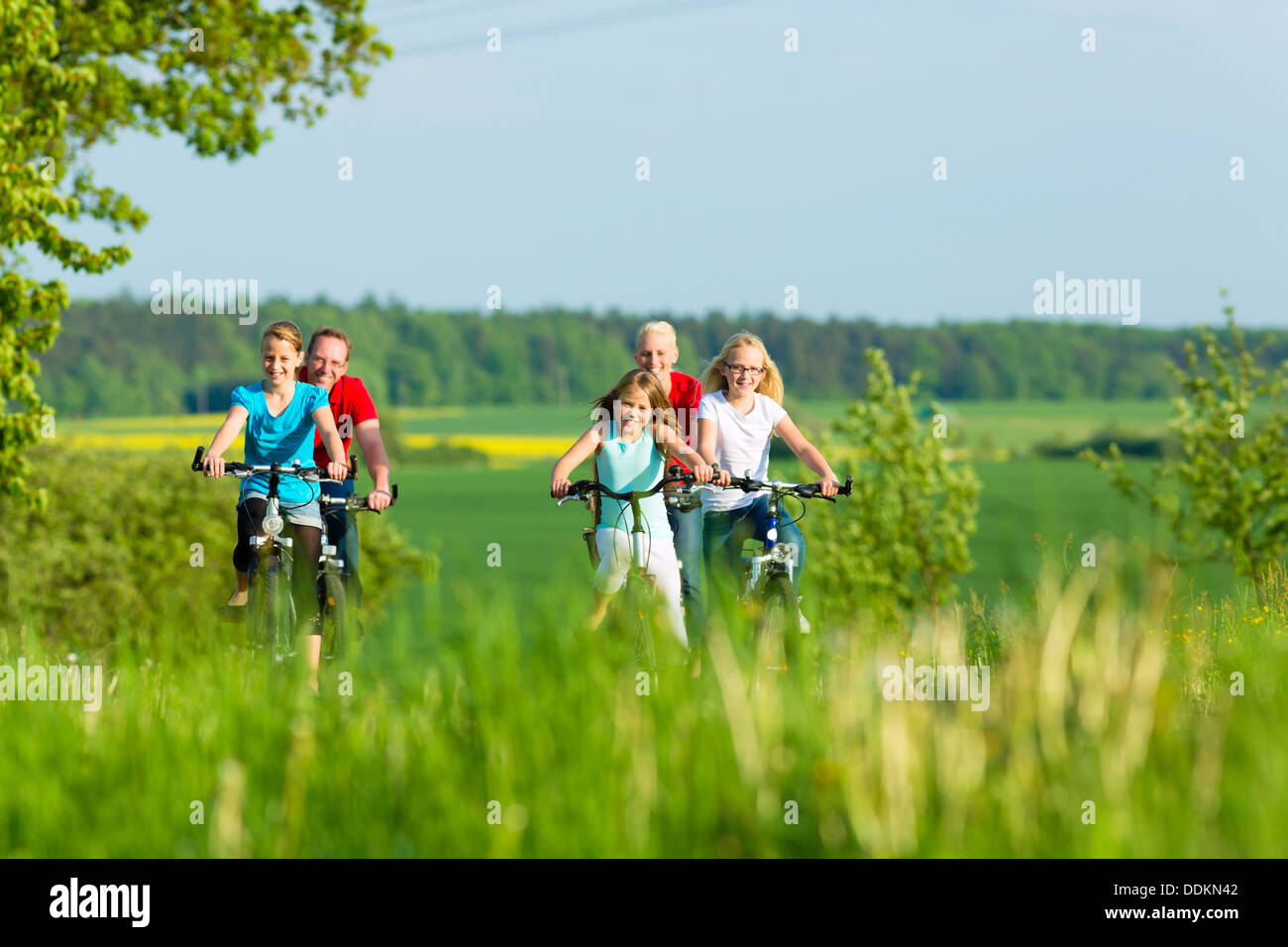 Family with three girls having a weekend excursion on their bikes on a ...