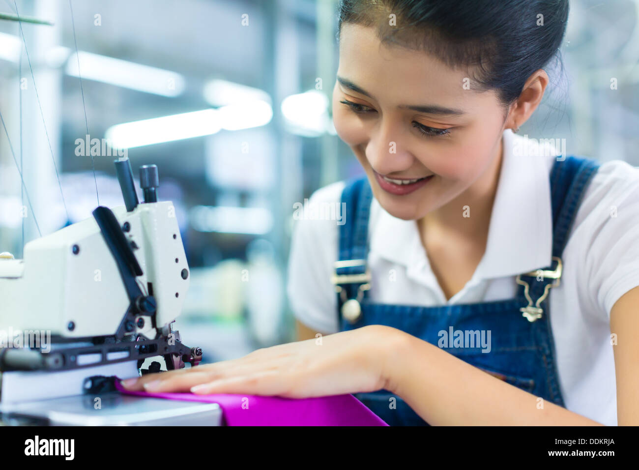 Asian Seamstress or worker in a Indonesian factory sewing with a ...