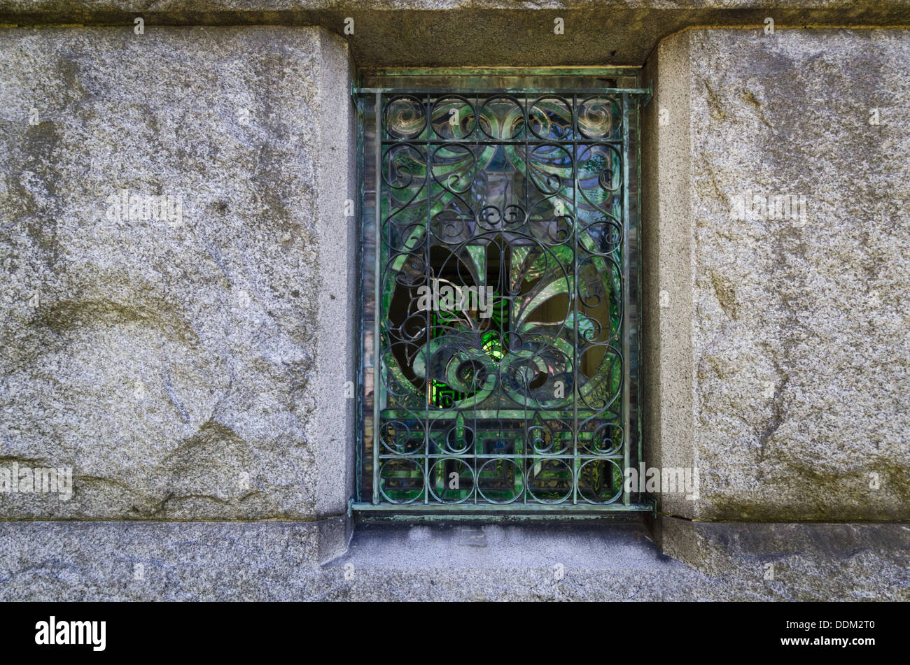 Broken window in a mausoleum with ornate wrought iron scroll work and ...