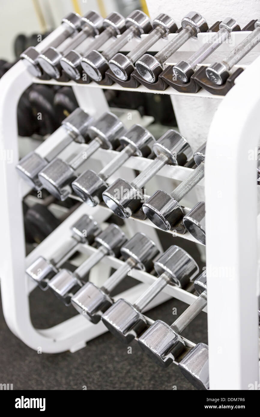 Stand with dumbbells. Sports and fitness room Stock Photo - Alamy
