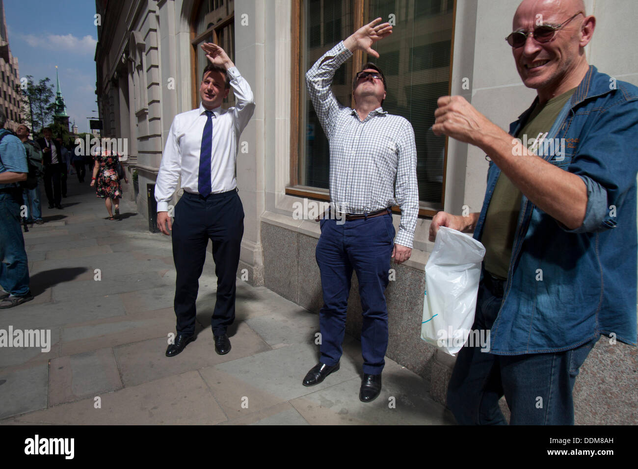 London, UK. 4th September 2013. Office workers cover their faces as the ...