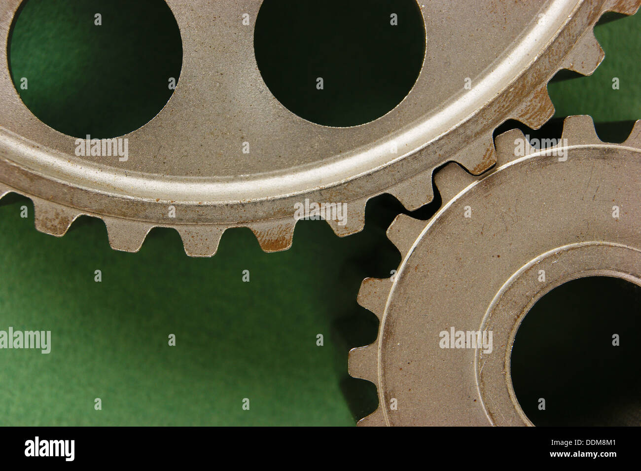 Two gears on a green background Stock Photo - Alamy