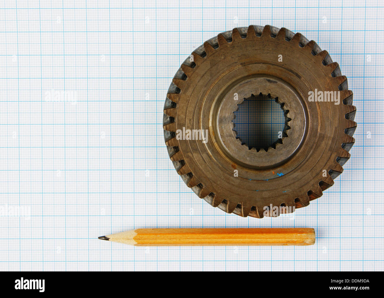 Gear and pencil on graph paper Stock Photo - Alamy