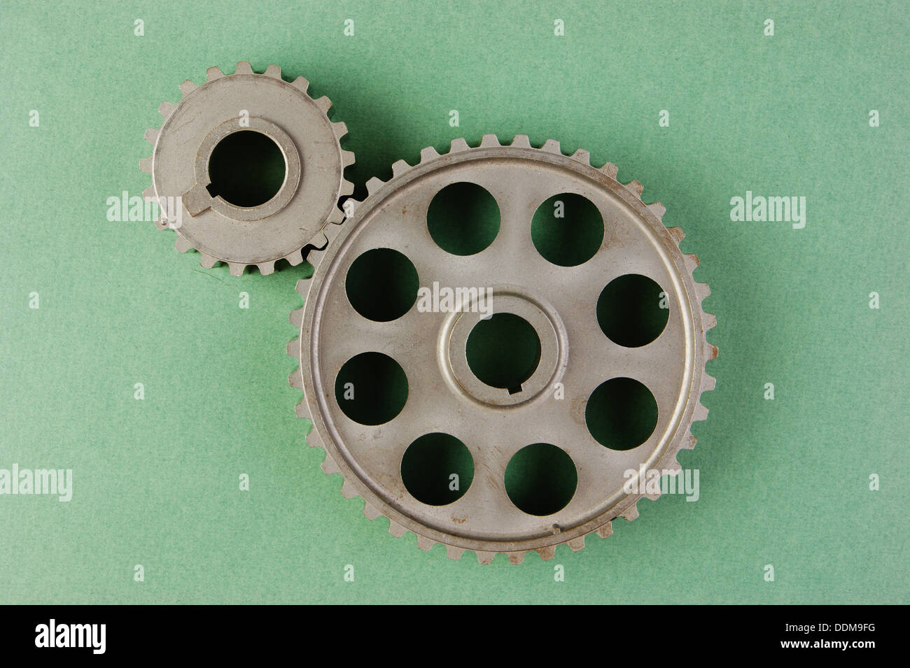 Two gears on a green background Stock Photo - Alamy