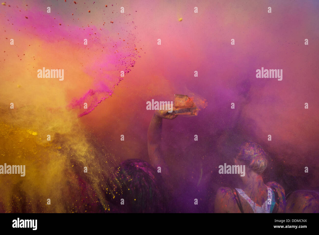 people throwing rainbow colored powder in a crowd Stock Photo - Alamy