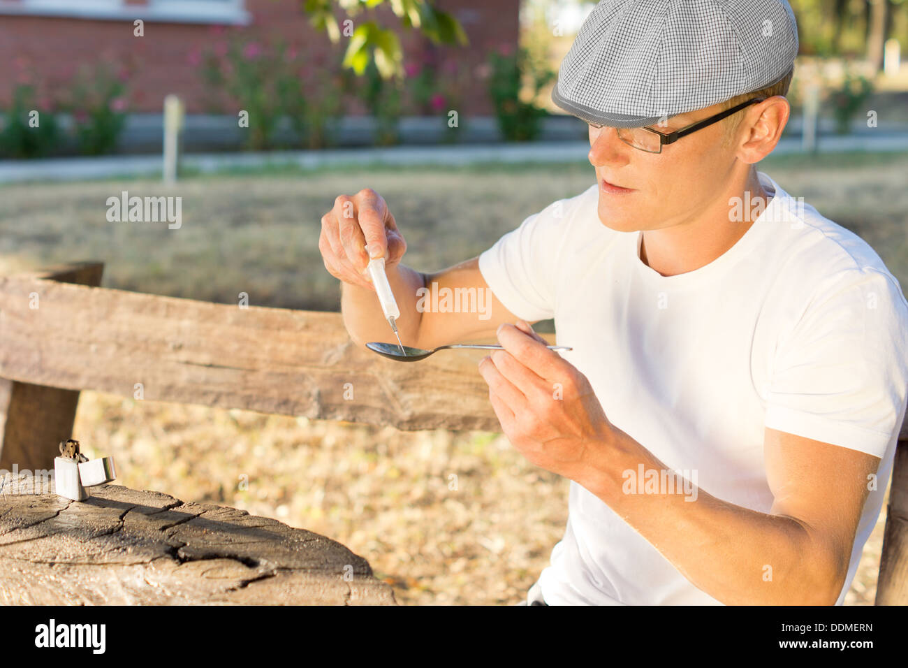Middle-aged Caucasian man filling a syringe with addictive soluble ...