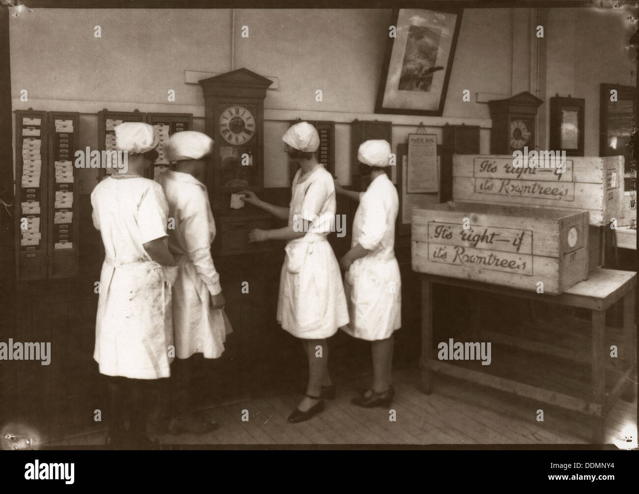 Girls use the clocking in machine, Rowntree factory, York, Yorkshire ...