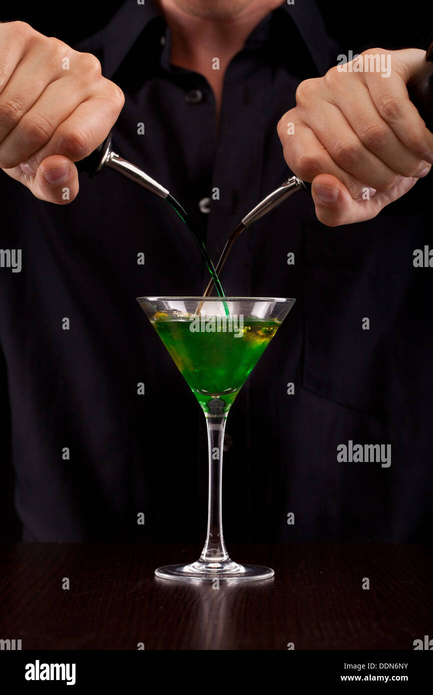 Bartender pours alcoholic drink into cocktail glass Stock Photo - Alamy