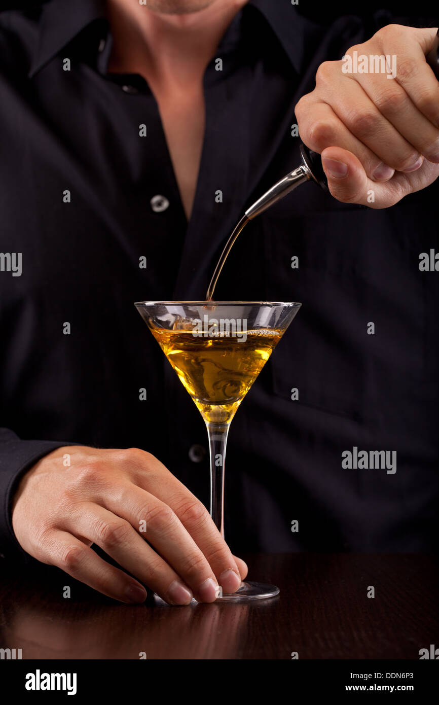 Bartender pours alcoholic drink into cocktail glass Stock Photo - Alamy