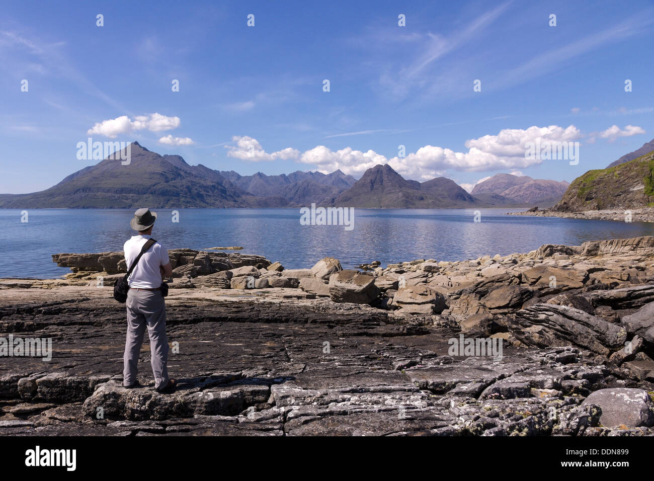 Male holidaymaker admiring view from Elgol over Sea Loch Scavaig to the ...
