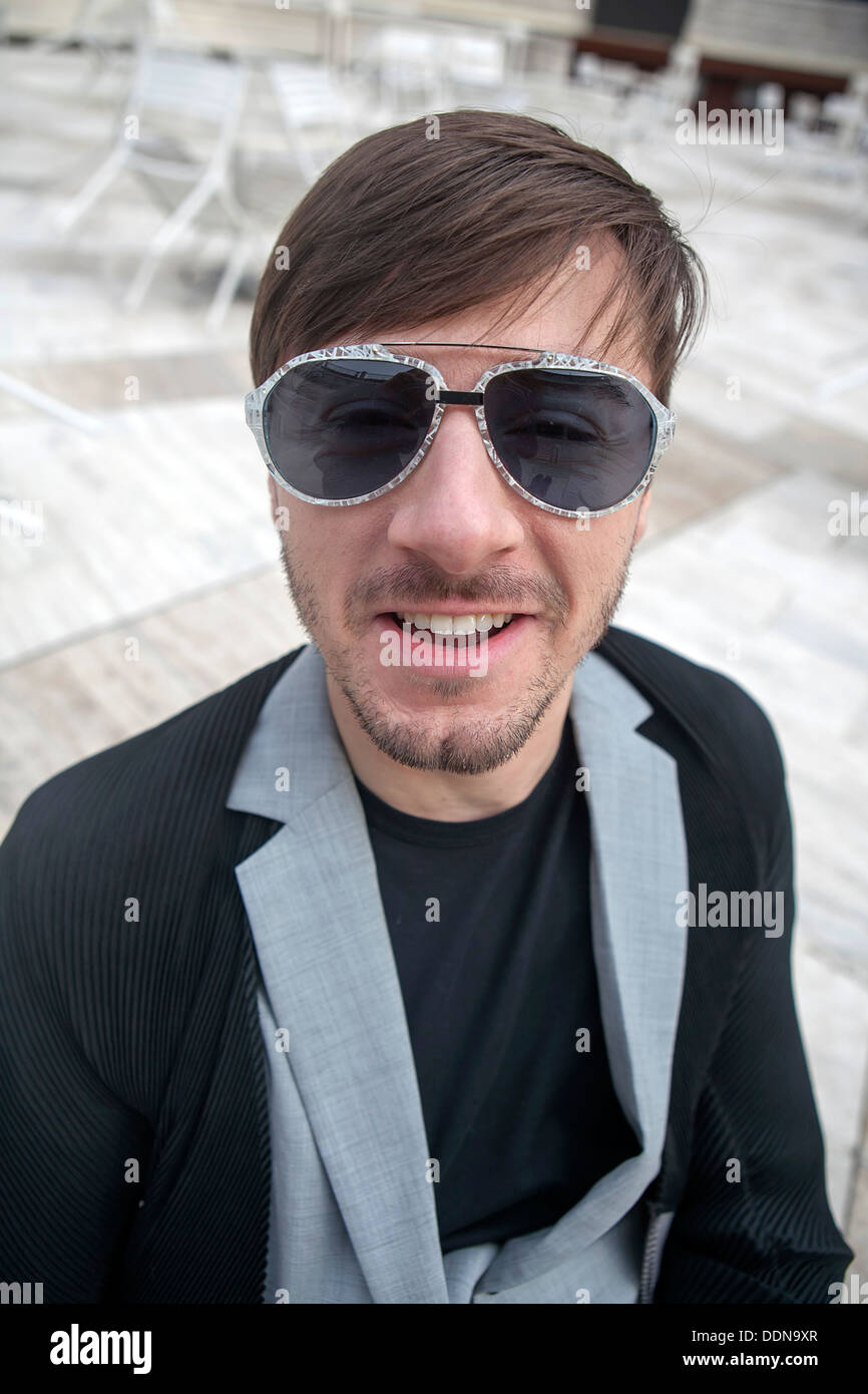 strange silly funny man wearing black coat sitting on the street cafe ...