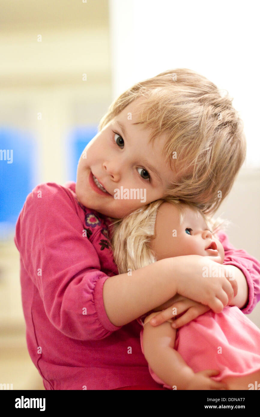 Blond girl embracing her puppet Stock Photo - Alamy
