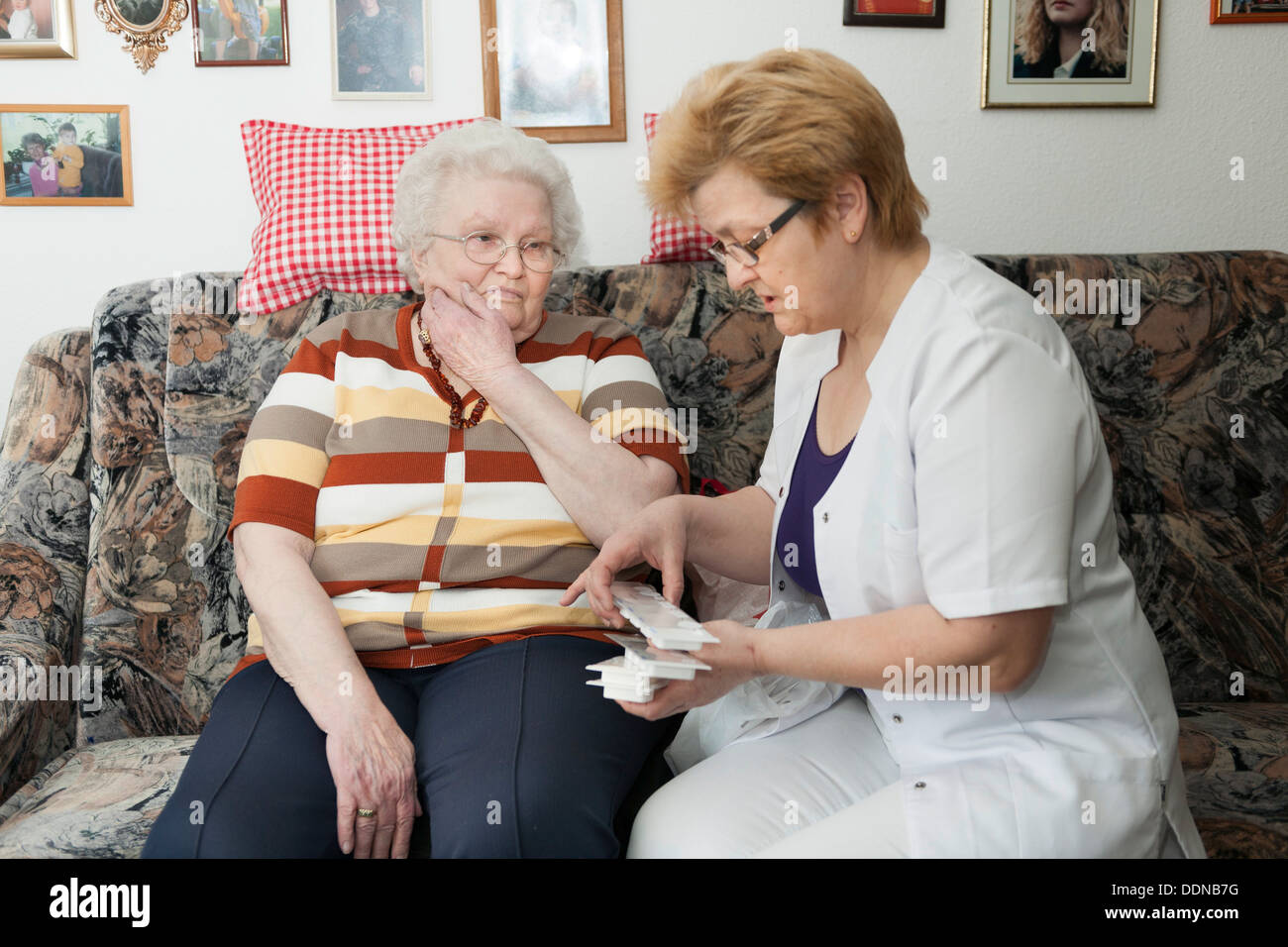 Geriatric nurse explaining medication to old woman Stock Photo - Alamy