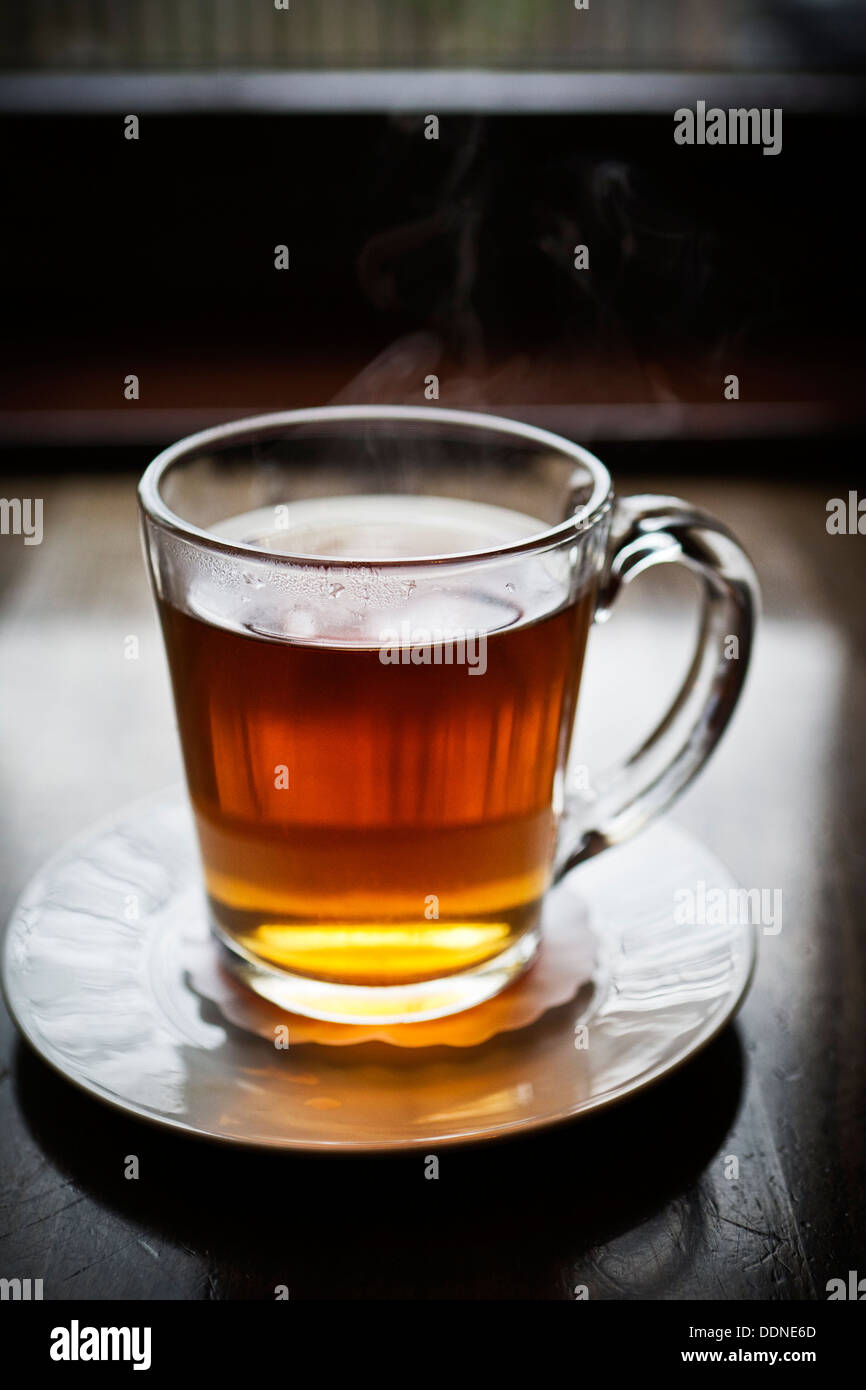 Glass of hot tea on saucer Stock Photo - Alamy