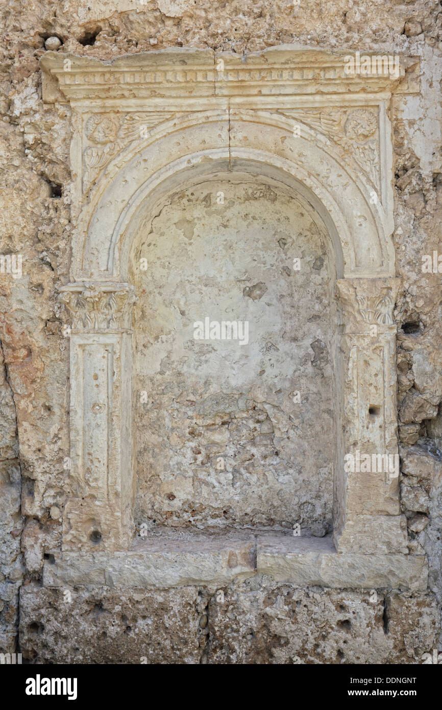 An ornately carved but crumbling wall niche on the outside of a ...