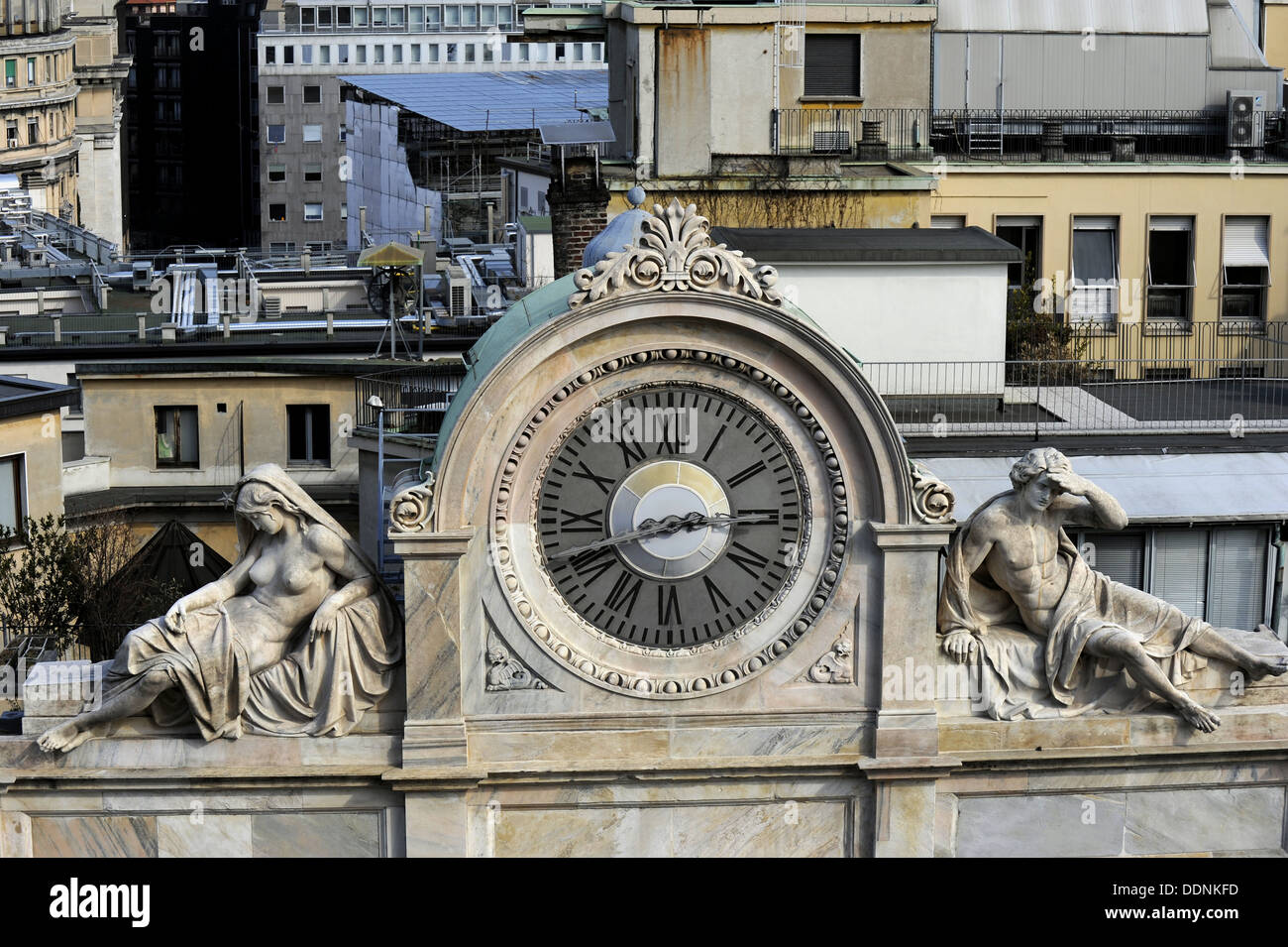 Italy. Milan. Clock decorated with two statues, one male and one female ...