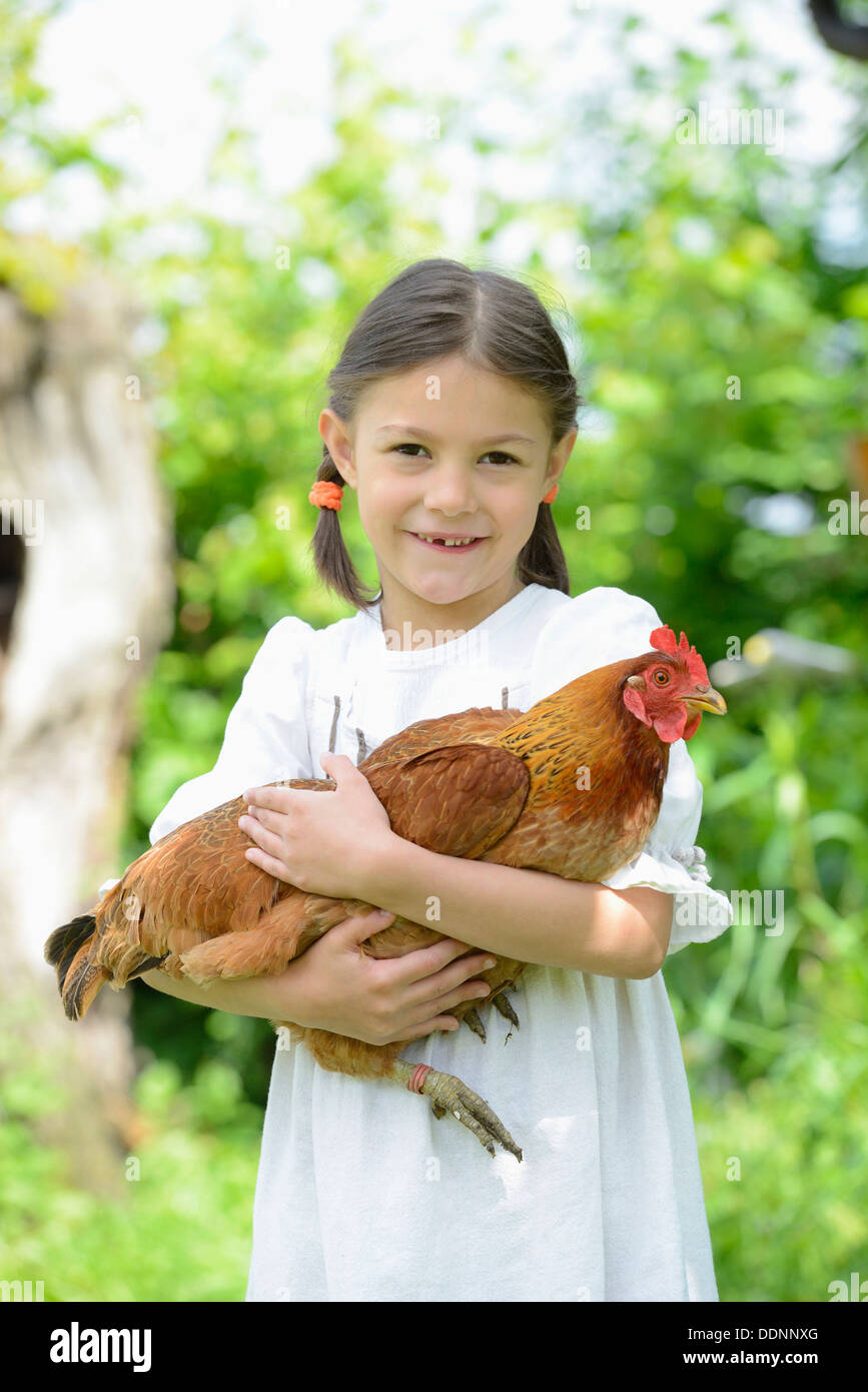 Girl holding a chicken Stock Photo - Alamy