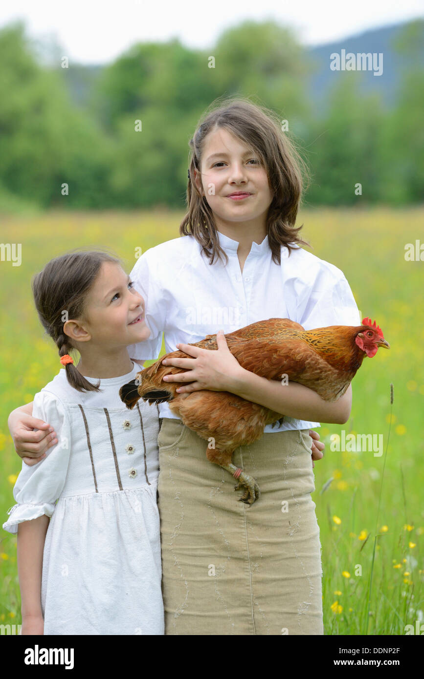 Two sisters with a chicken Stock Photo - Alamy