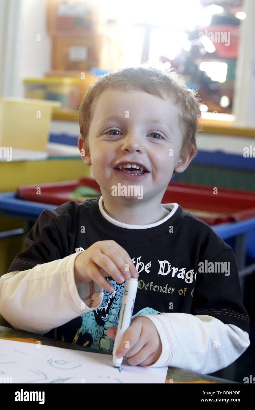 4 Year Old Boy Smiling Into Camera At Nursery Holding A Pen Stock 4-year-old-boy-smiling-into-camera-at-nursery-holding-a-pen-stock