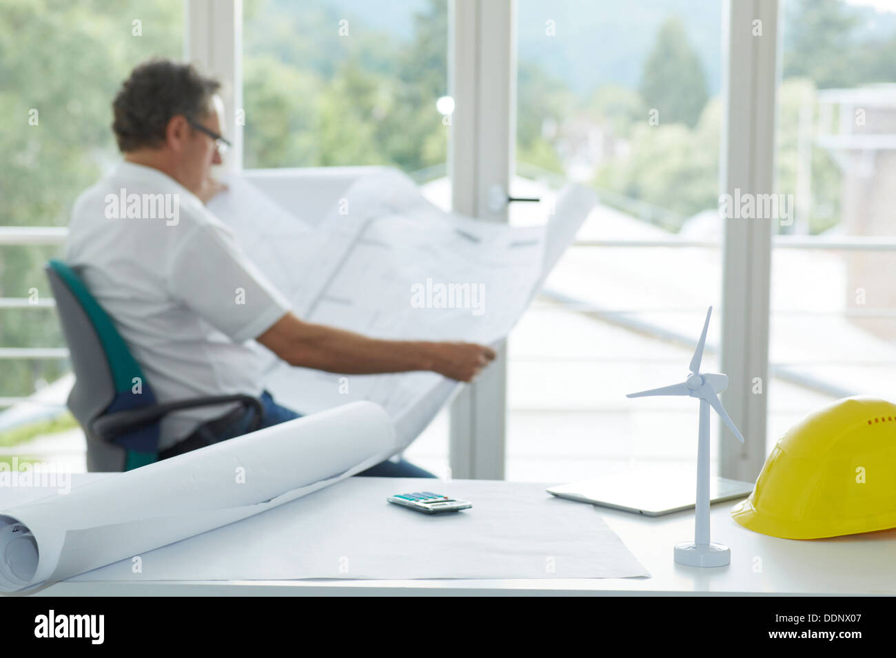 Engineer with blueprints in office Stock Photo - Alamy