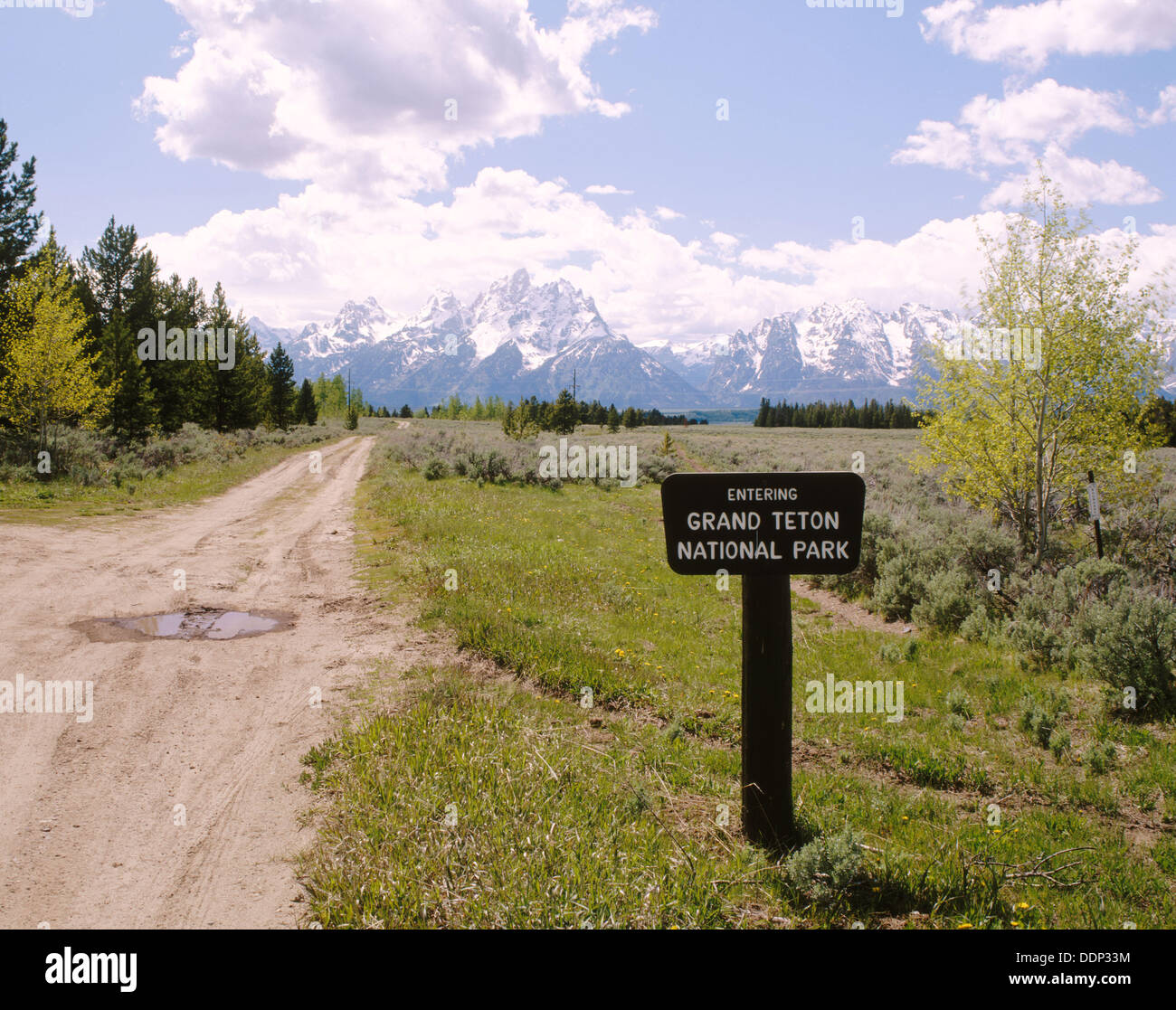 Road and sign entering, Grand Teton National Park. Teton Mountain Range ...