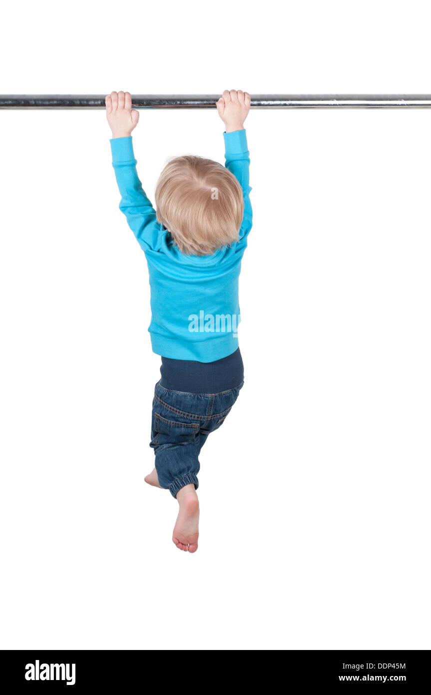 Little boy in blue hanging on the bar Stock Photo - Alamy