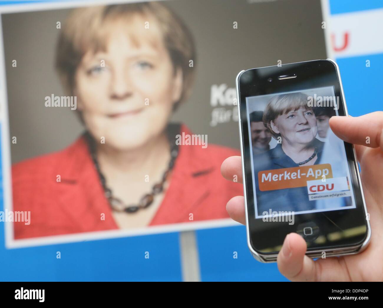 A smartphone is held in front of an election poster with the portrait ...