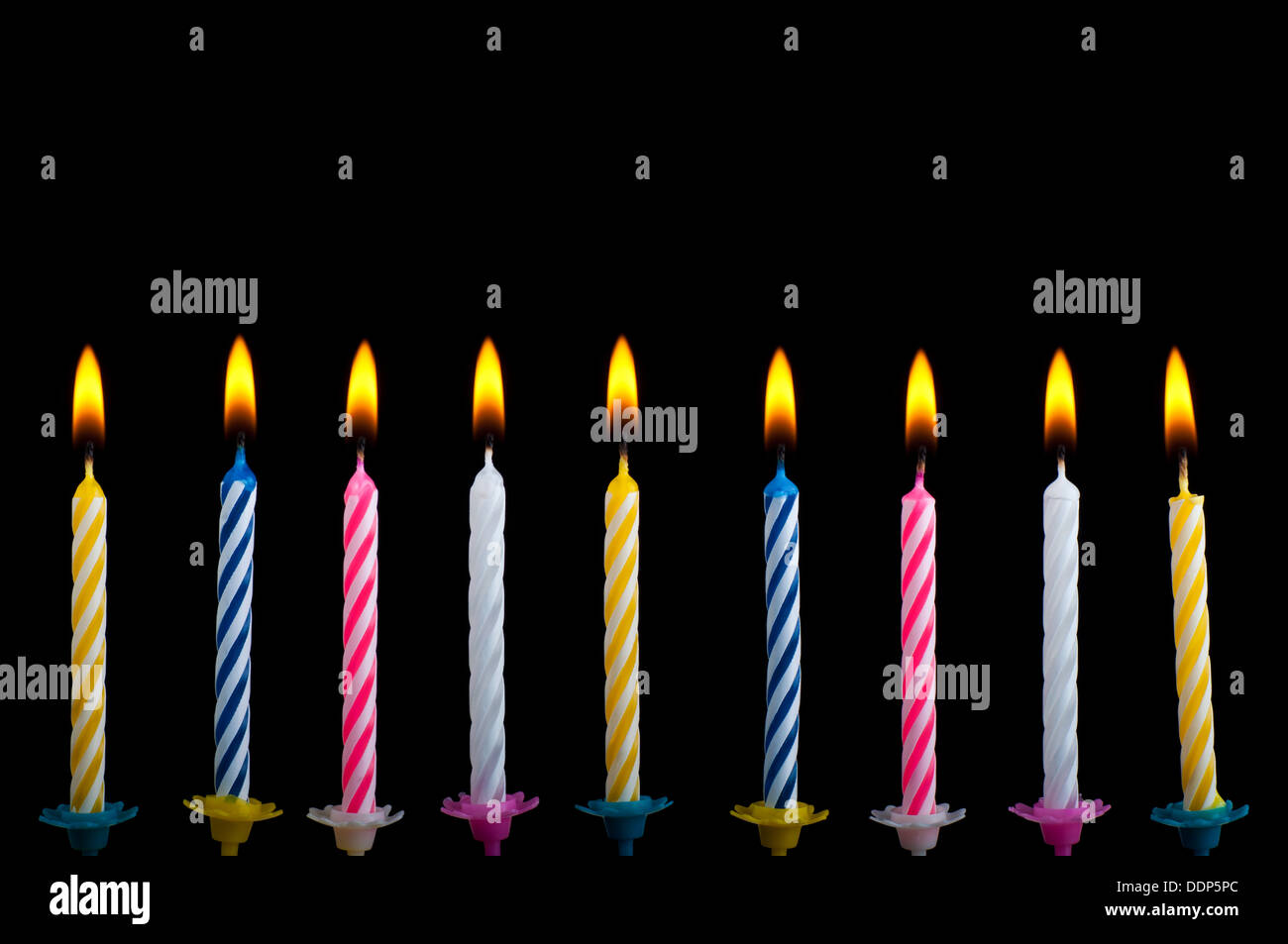 Birthday colour candles with fire on black background Stock Photo - Alamy
