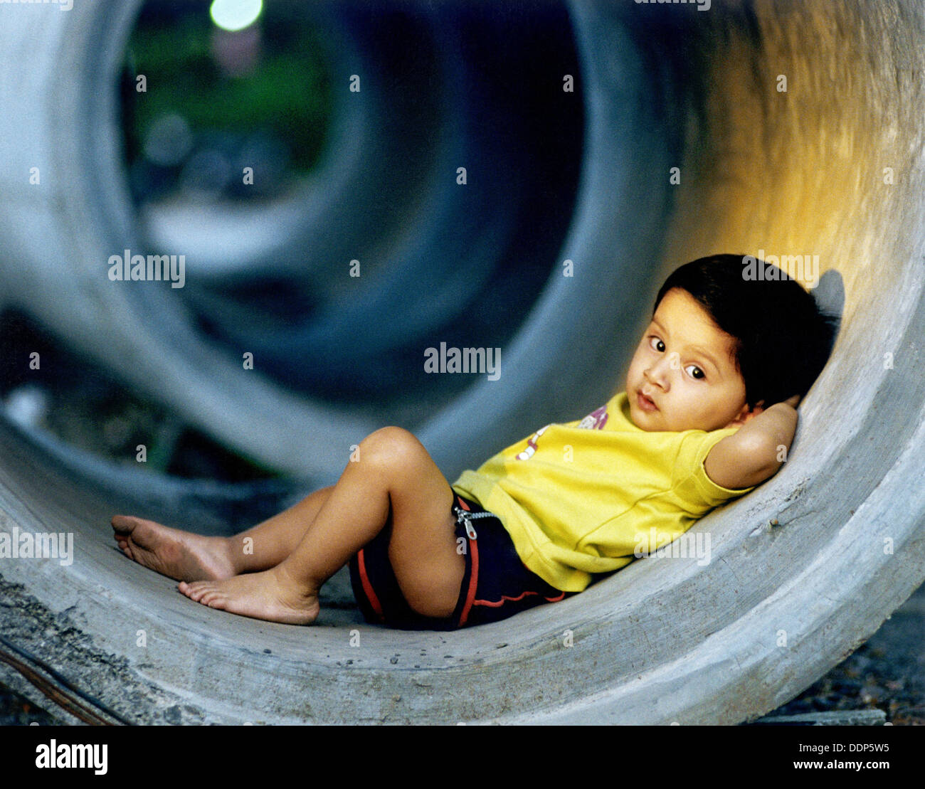 A kid leaning in tube Stock Photo - Alamy