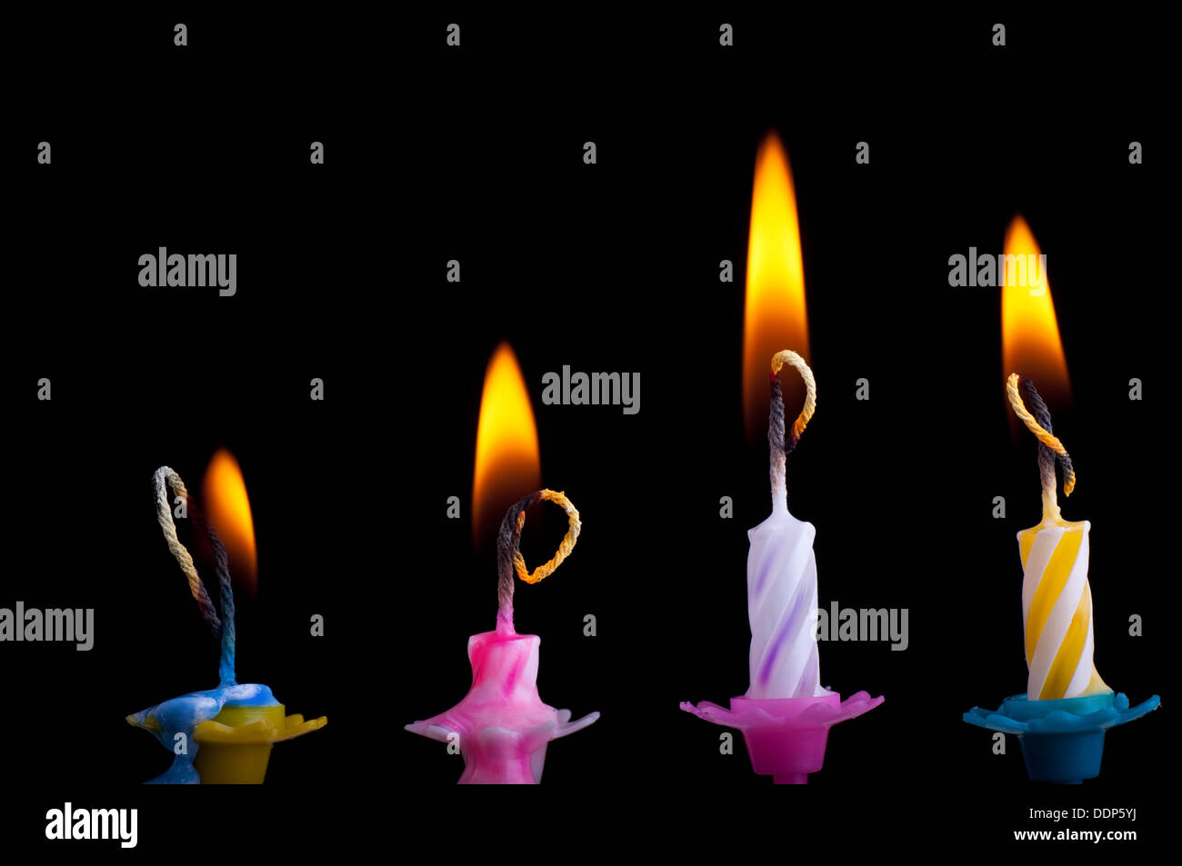 Birthday colour candles with fire on black background Stock Photo - Alamy