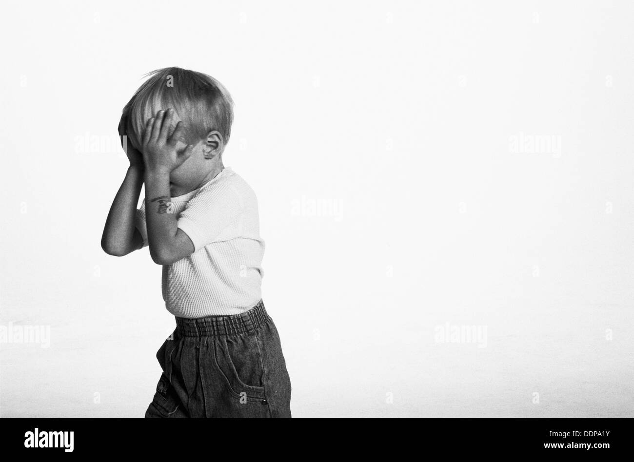 image of young boy with hands over face Stock Photo - Alamy