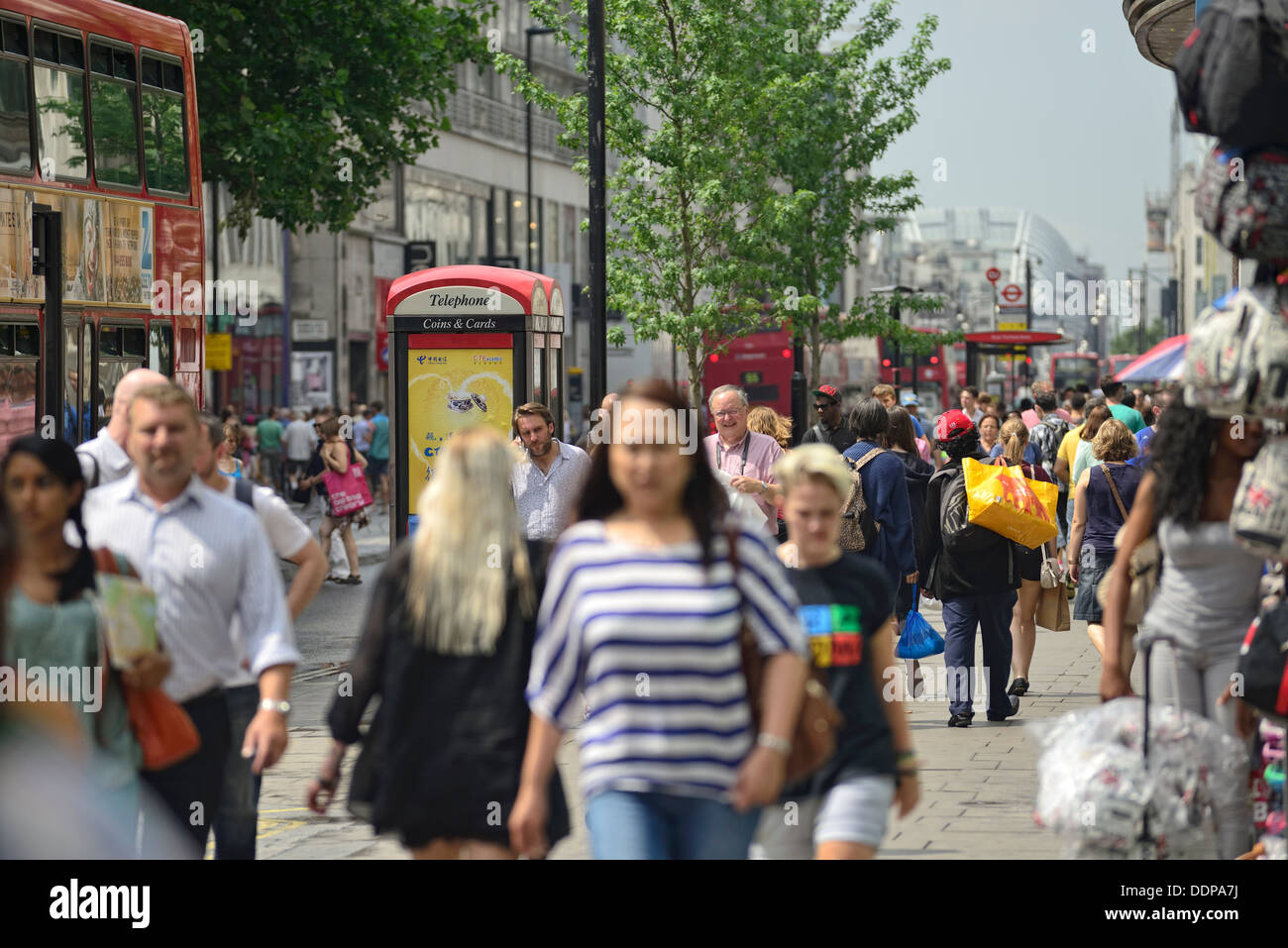 Busy London Street, with typical red double decker and people rusing ...