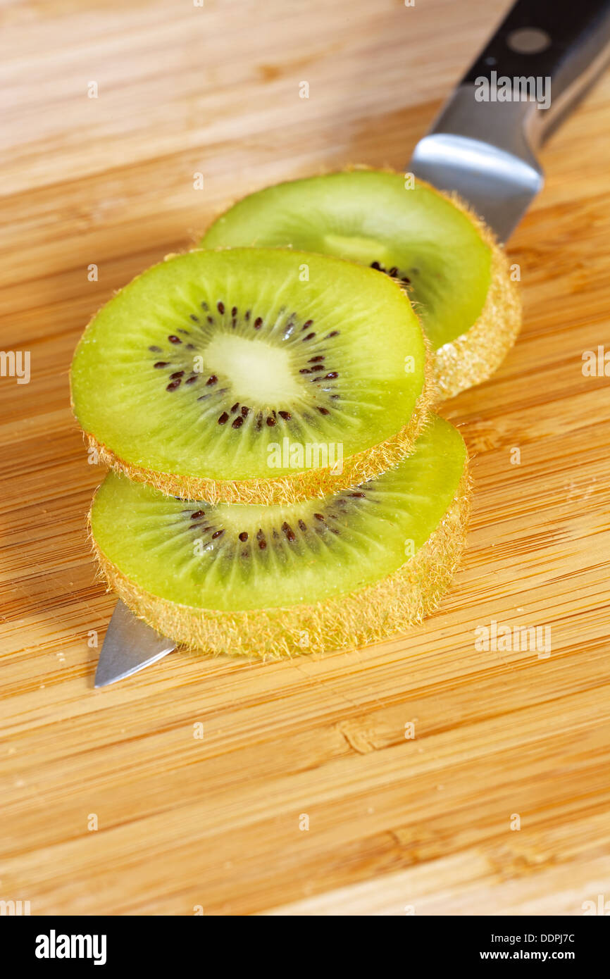Kiwi sliced with knife on a wooden cutting board Stock Photo - Alamy